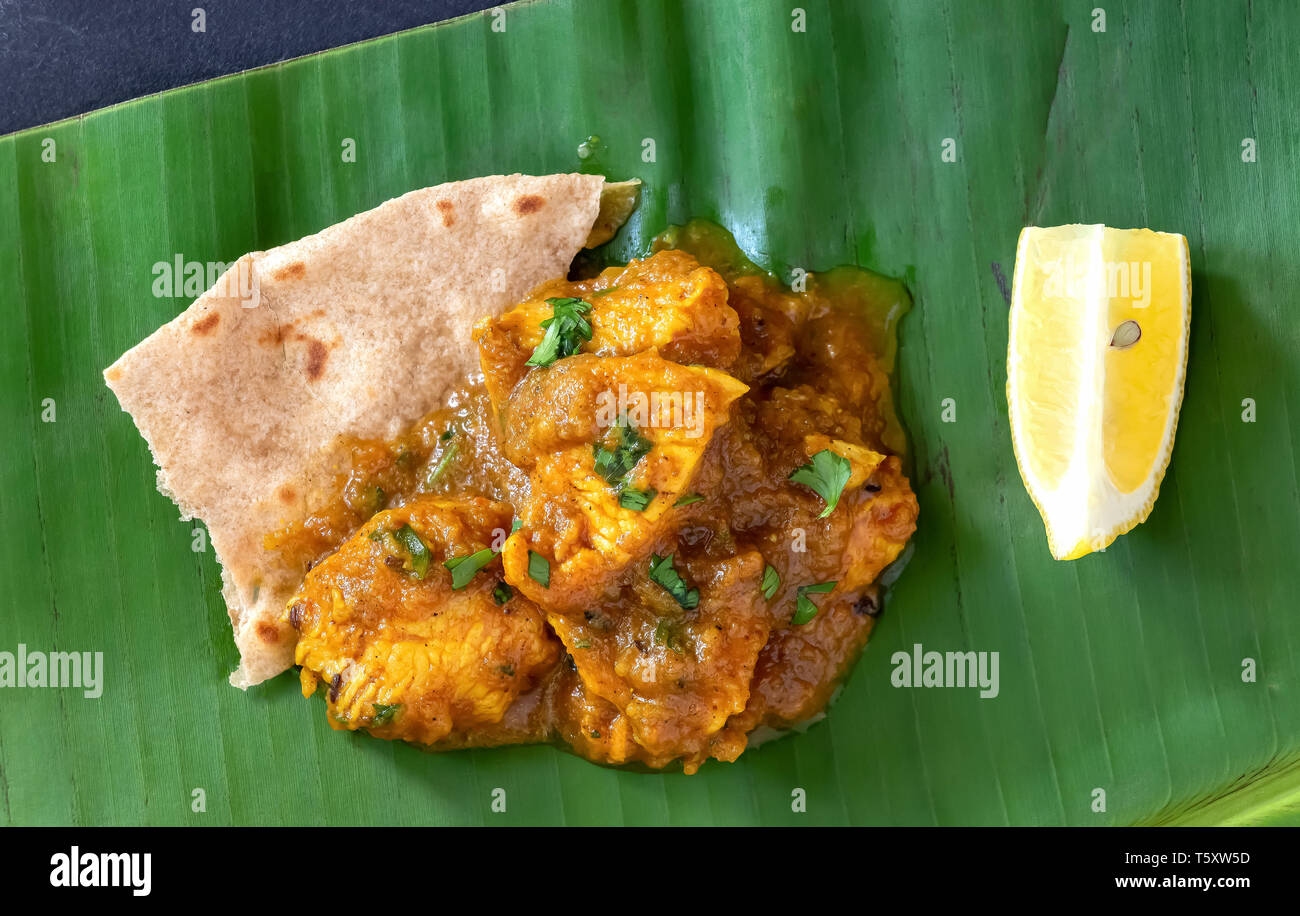 Close up traditional Indian butter chicken curry and lemon served with ...