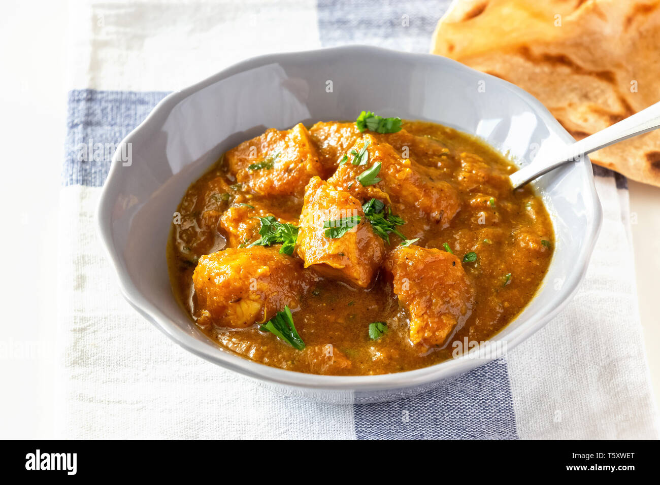 Close up traditional Indian butter chicken curry and lemon served with ...