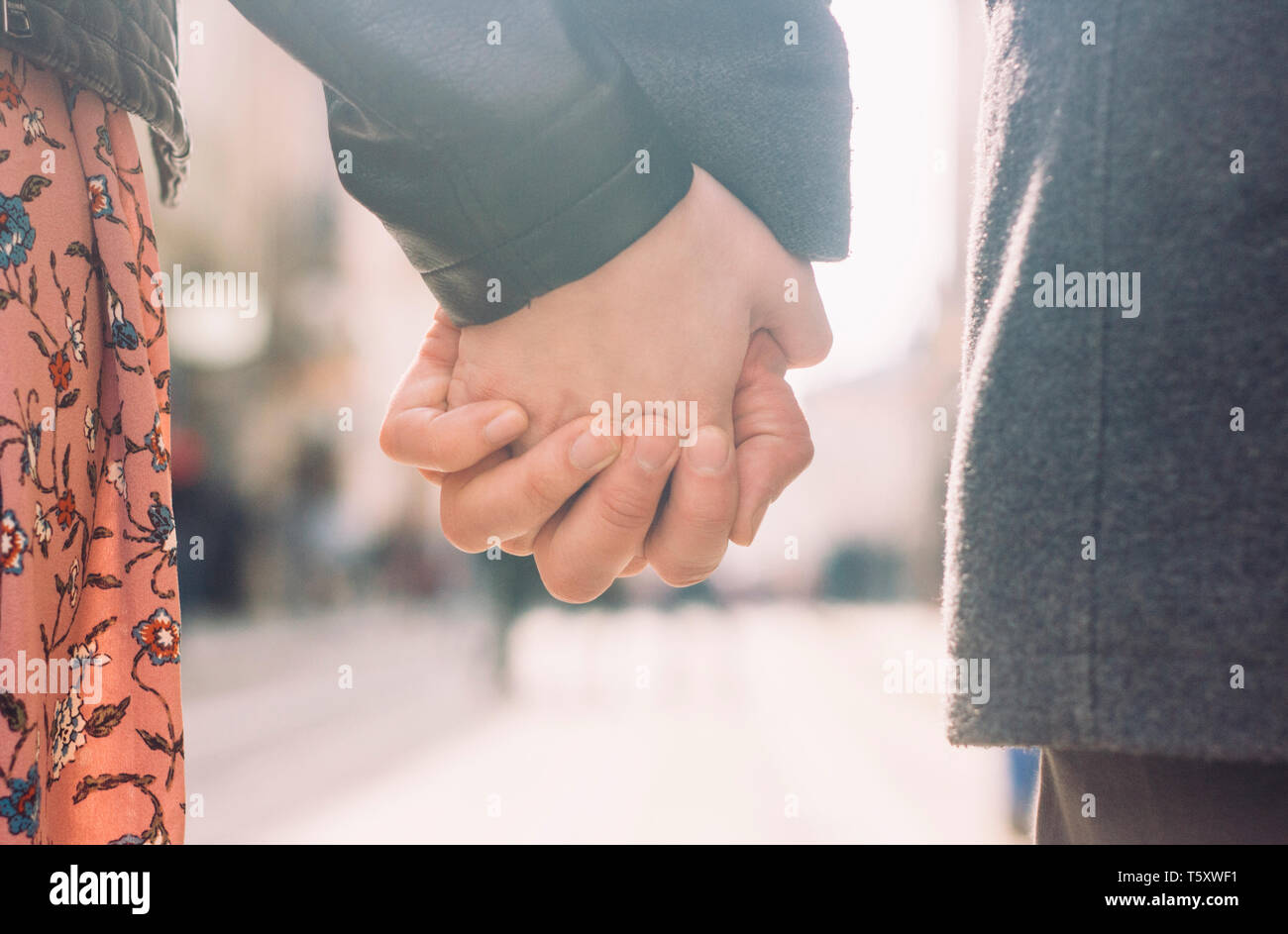 Couple holding hands in the street close up. Concept of love and ...