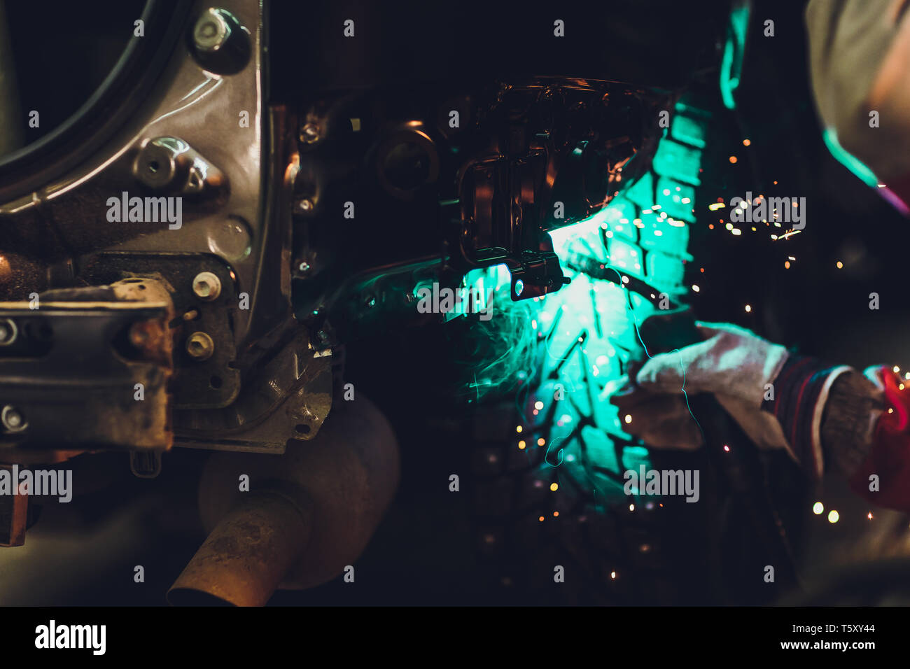 professional repairman worker in automotive industry welding metal body ...