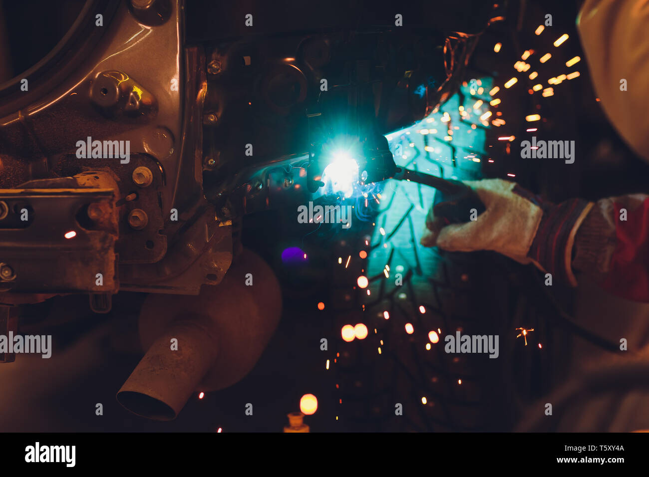 professional repairman worker in automotive industry welding metal body ...