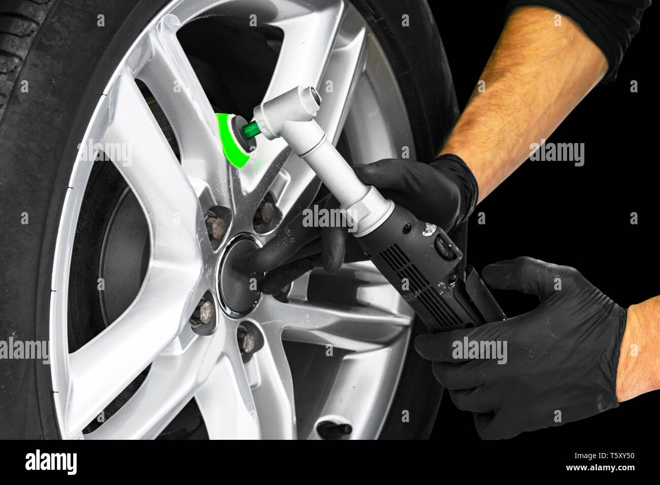 Car polish wax worker hands polishing car wheel. Buffing and polishing ...
