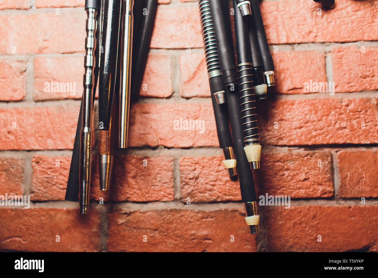 many pipes from hookah hanging on the wall Stock Photo - Alamy