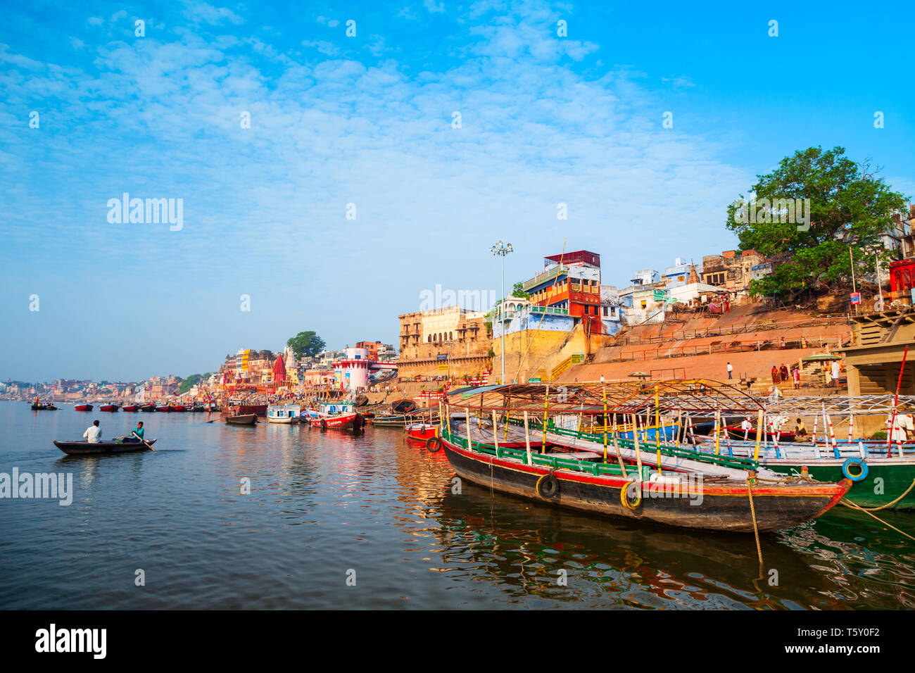 VARANASI, INDIA - APRIL 12, 2012: Colorful boats and Ganges river bank ...
