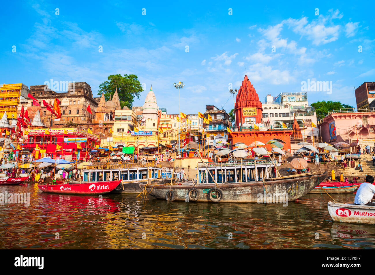 VARANASI, INDIA - APRIL 12, 2012: Colorful boats and Ganges river bank ...