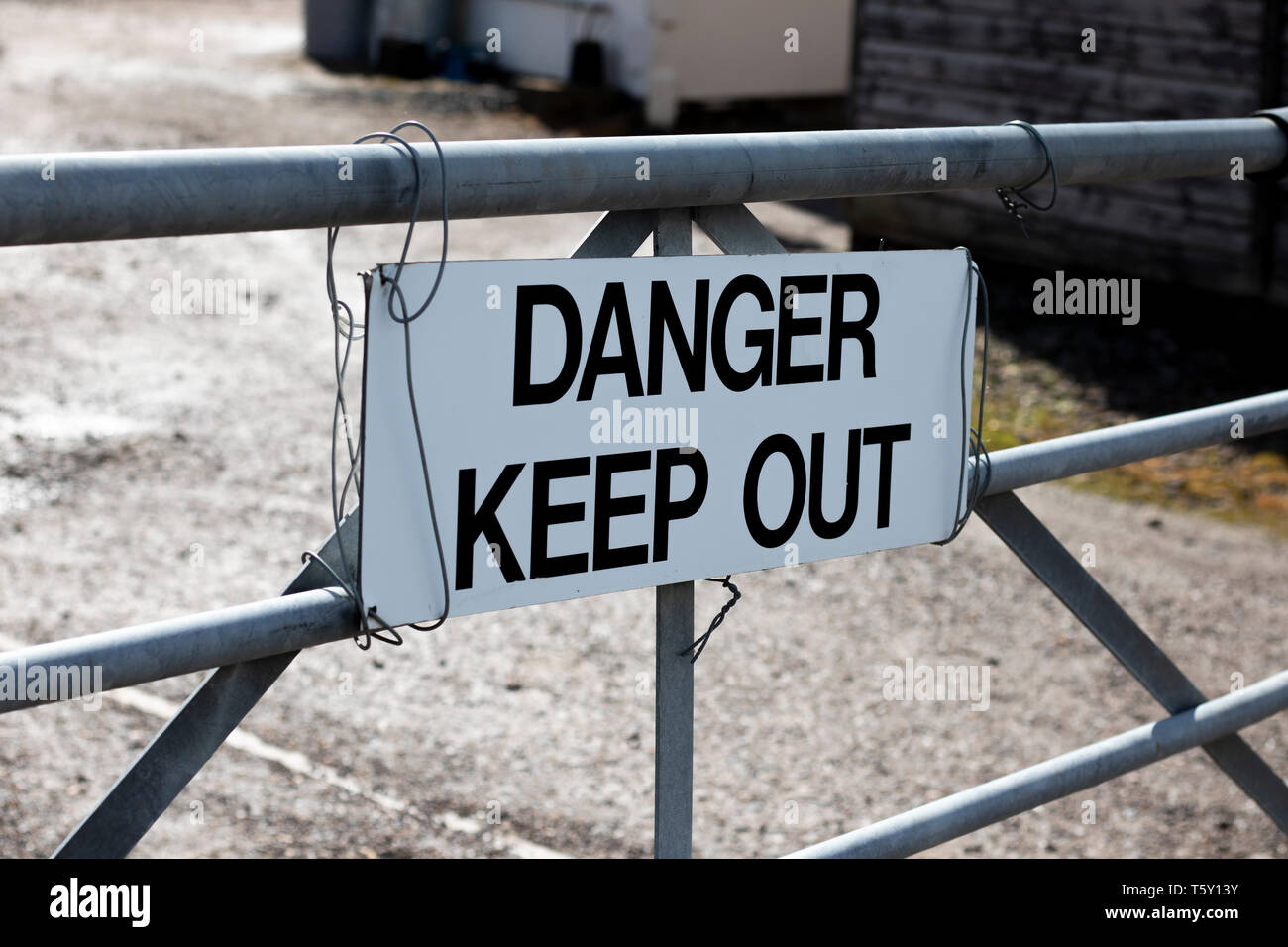 Danger keep out sign on metal gate boundary to disused contaminated ...