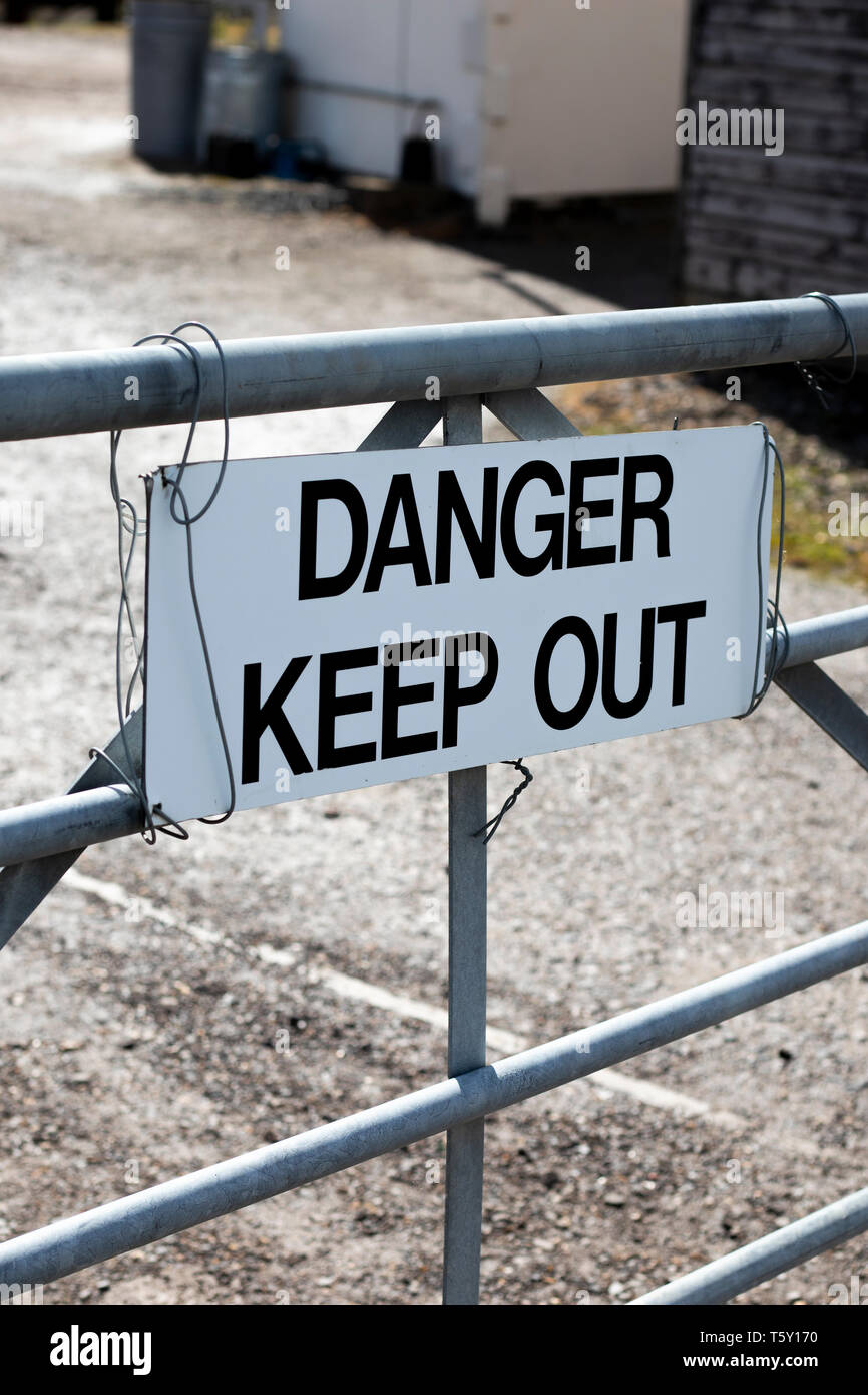 Danger keep out sign on metal gate boundary to disused contaminated ...