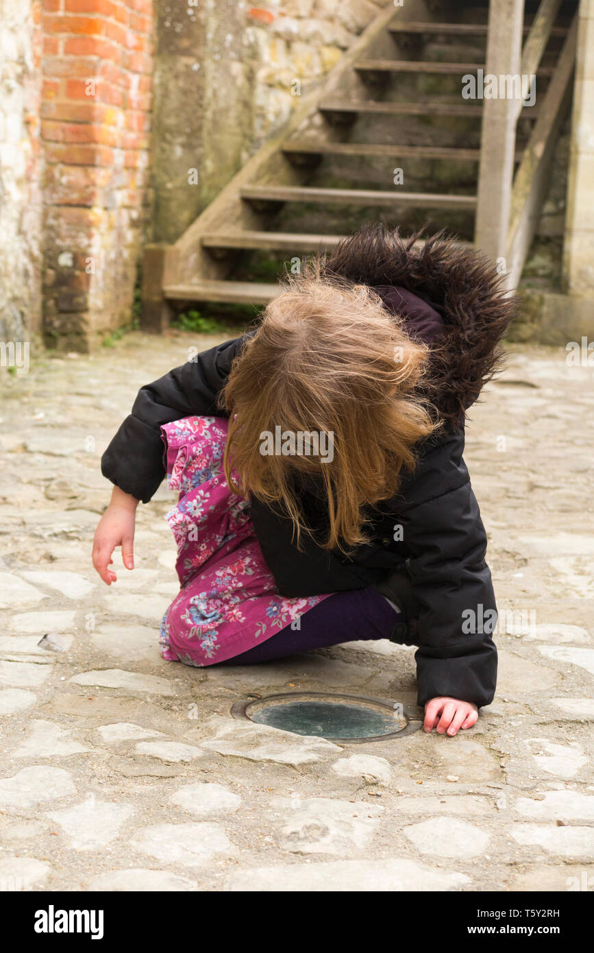 Child / kid looking down through the murder hole (through which ...