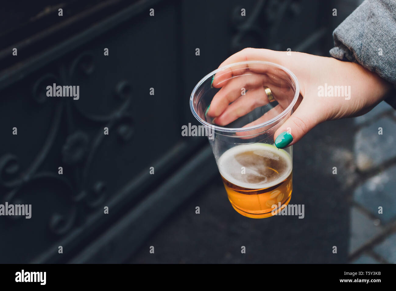 Fresh beer in a plastic cup in the hand Stock Photo - Alamy