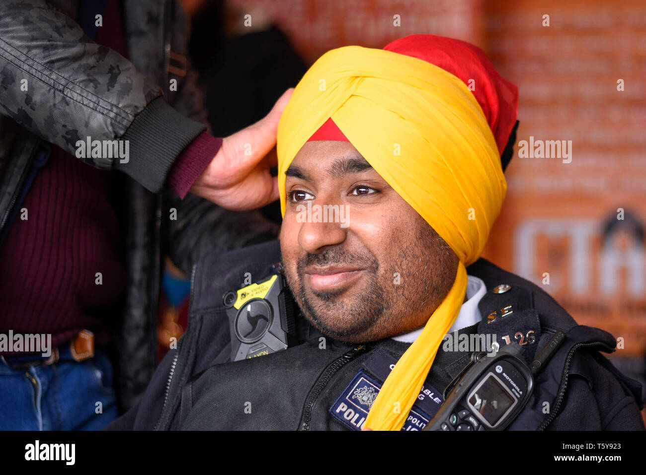 London, UK. 27 April 2019. A police officer has a turban tied during ...