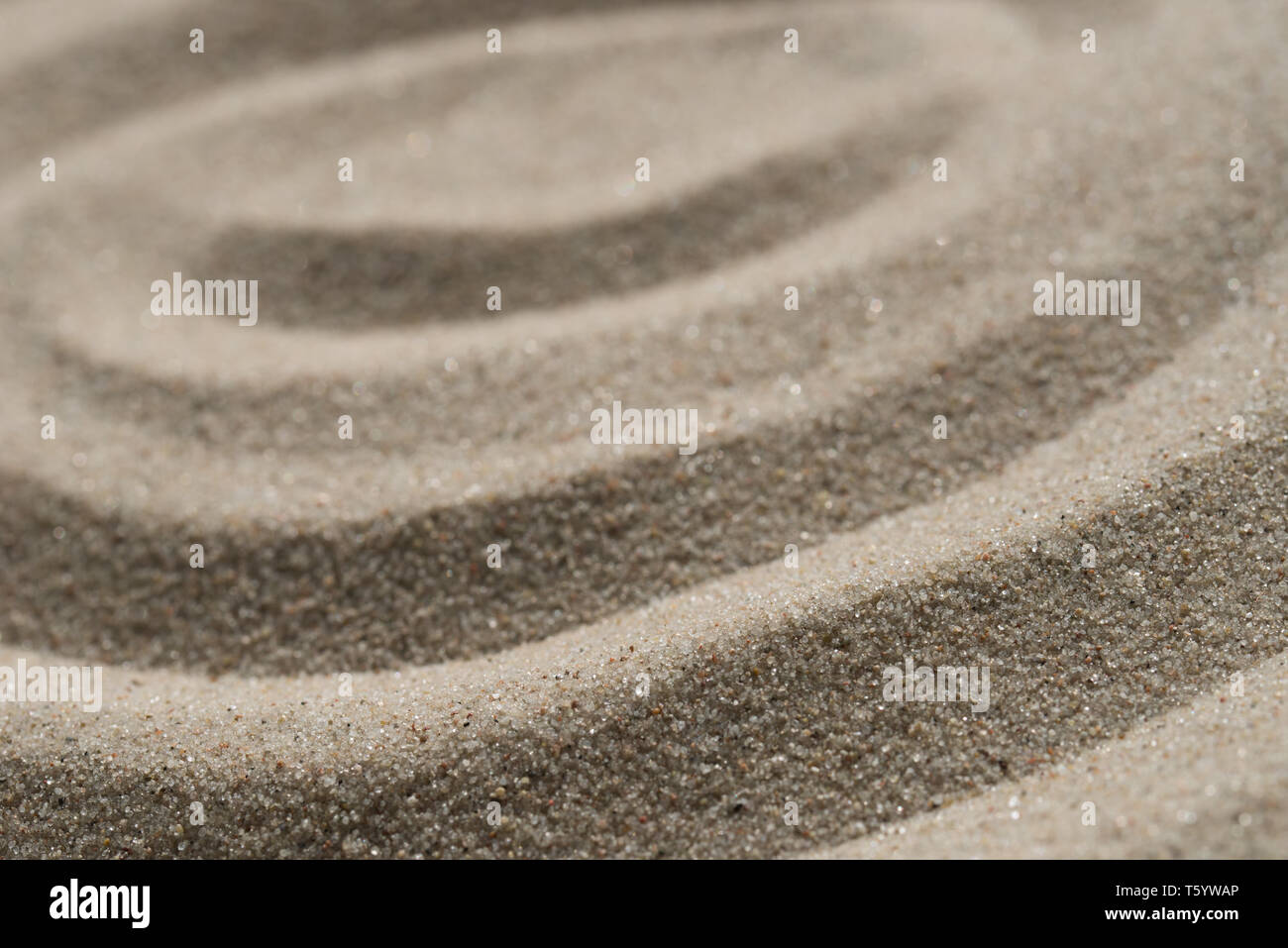 concentric circles pattern on natural sand texture background closeup ...