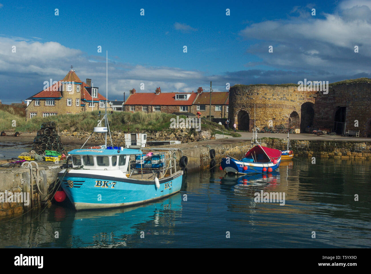 Fishing boats in Beadnell harbour with historic limekilns to the rear ...