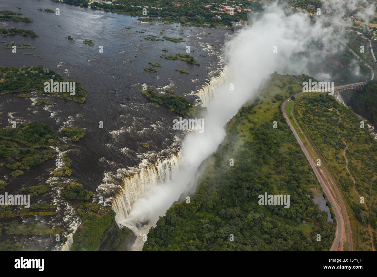 aerial view of the wide river's edge and long drop at Victoria Falls in ...