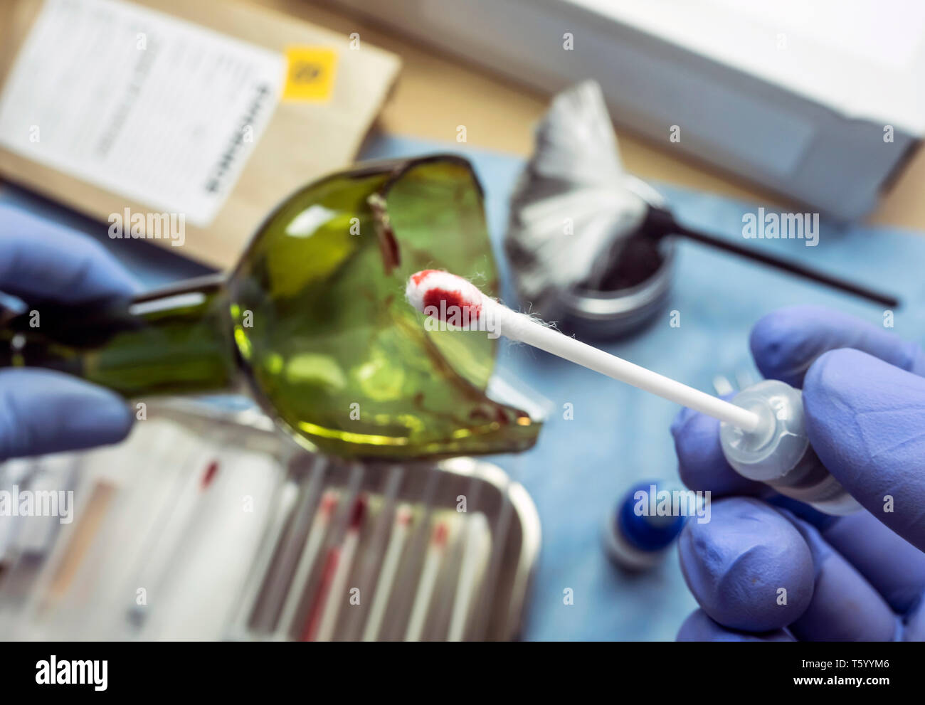 Police expert gets blood sample from a broken glass bottle in ...