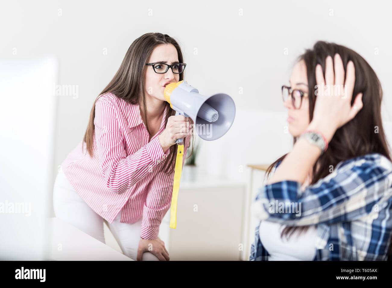 Businesswoman shouting at her colleague by using megaphone at the ...