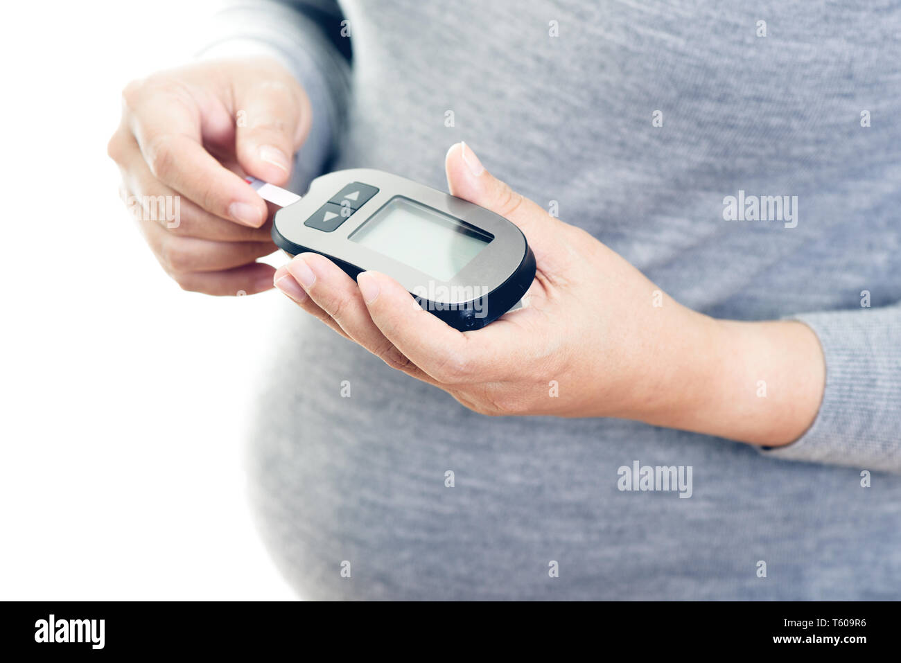 Pregnant woman checking blood sugar level with blood glucose meter ...