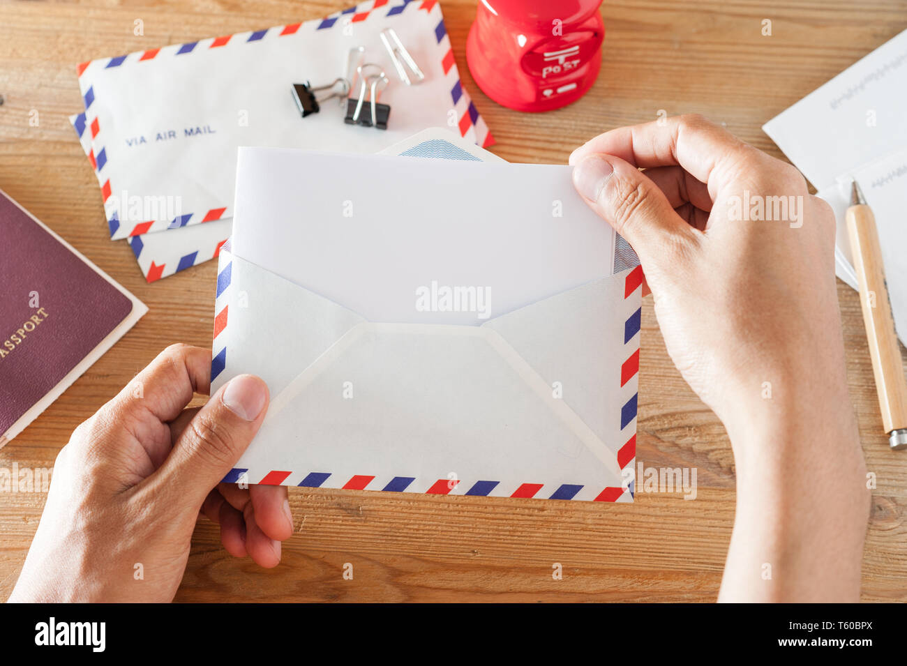 closeup man's hand opening an envelope over desktop Stock Photo - Alamy