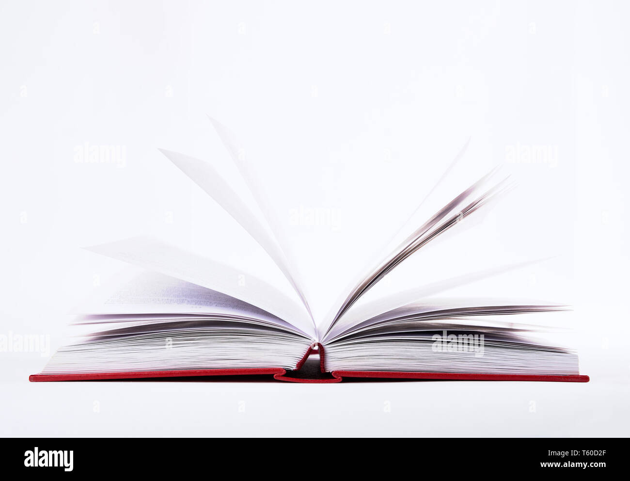 Closeup view of open book with pages in red hard cover with shadow ...