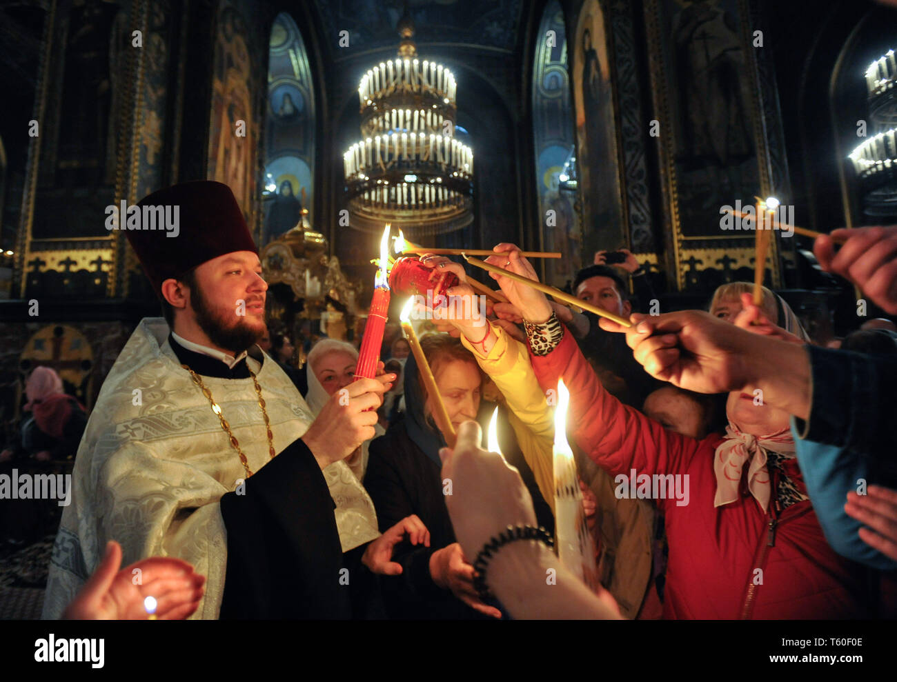 Ukrainian Orthodox faithful are seen lighting candles from the Holy ...