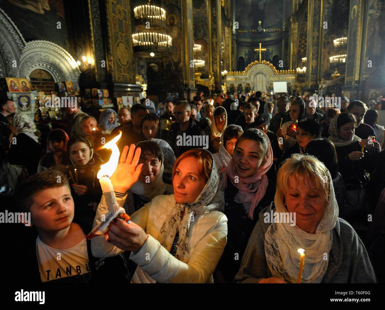 Ukrainian Orthodox faithful are seen lighting candles from the Holy ...