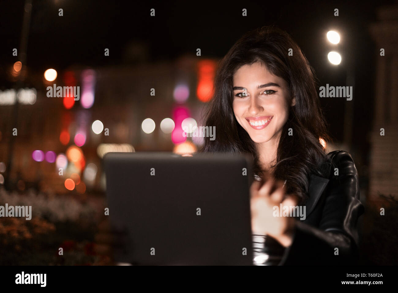 Happy girl making video-call on tablet in night city Stock Photo - Alamy
