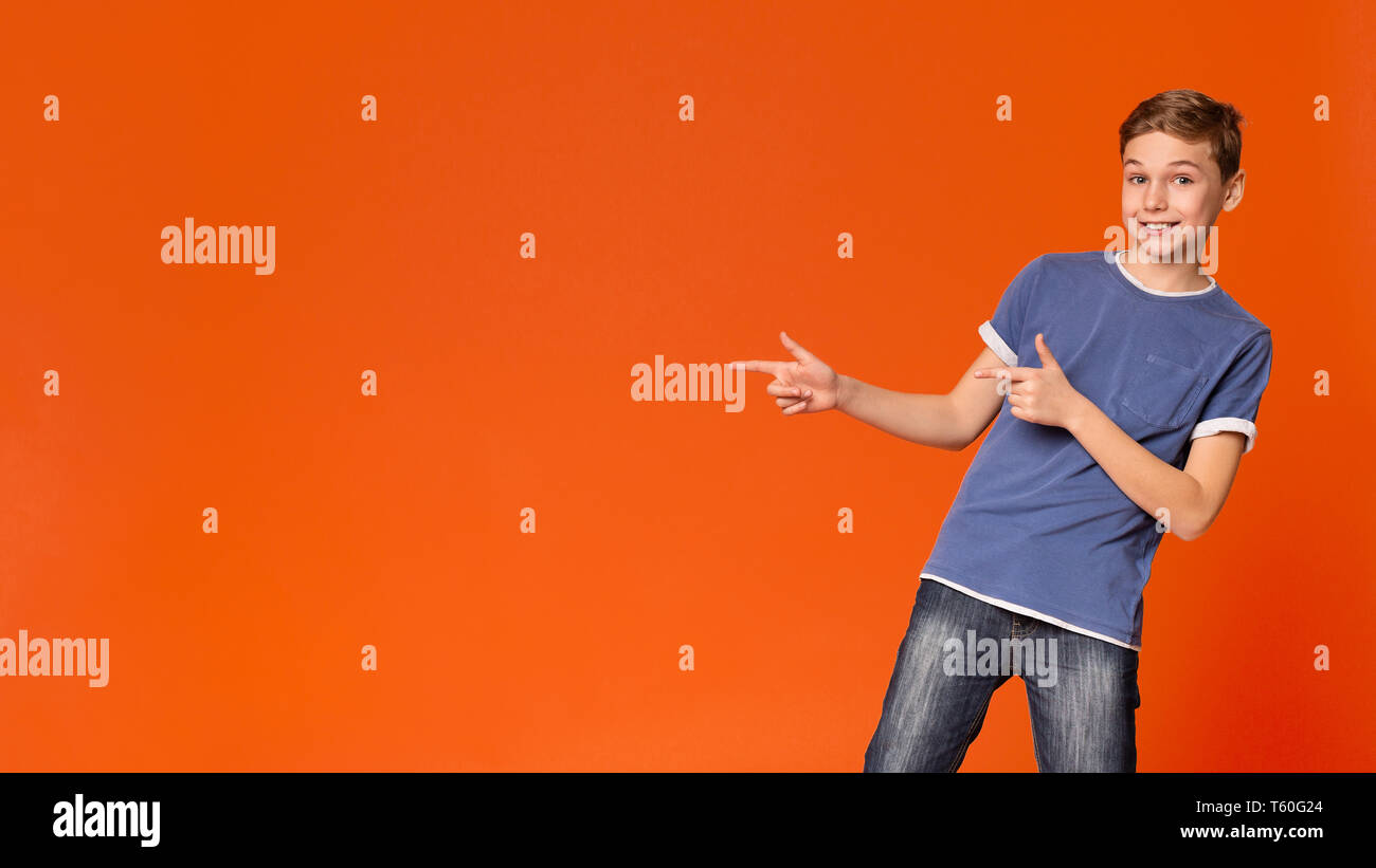 Adorable boy teenager pointing both hands aside Stock Photo - Alamy