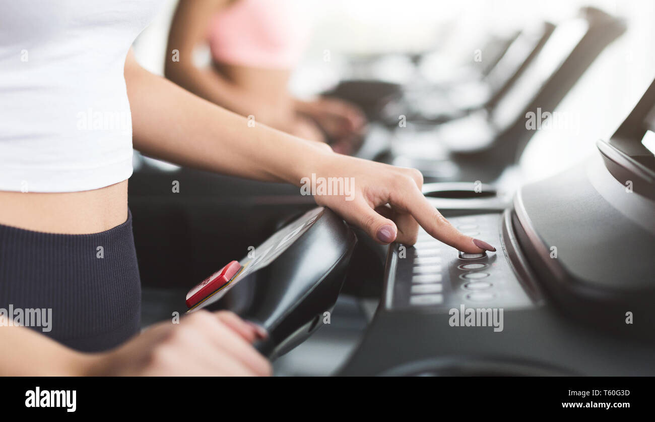 Adjusting speed. Woman exercising on treadmill, training in gym Stock ...