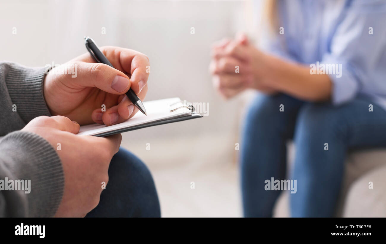 Psychologist noting problems of patient at therapy session Stock Photo ...