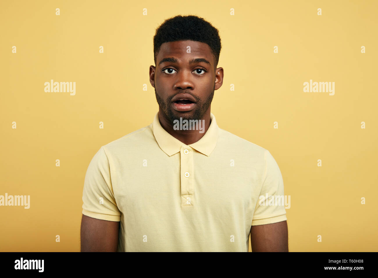 Bearded stylish awesome male having displeased look standing against ...