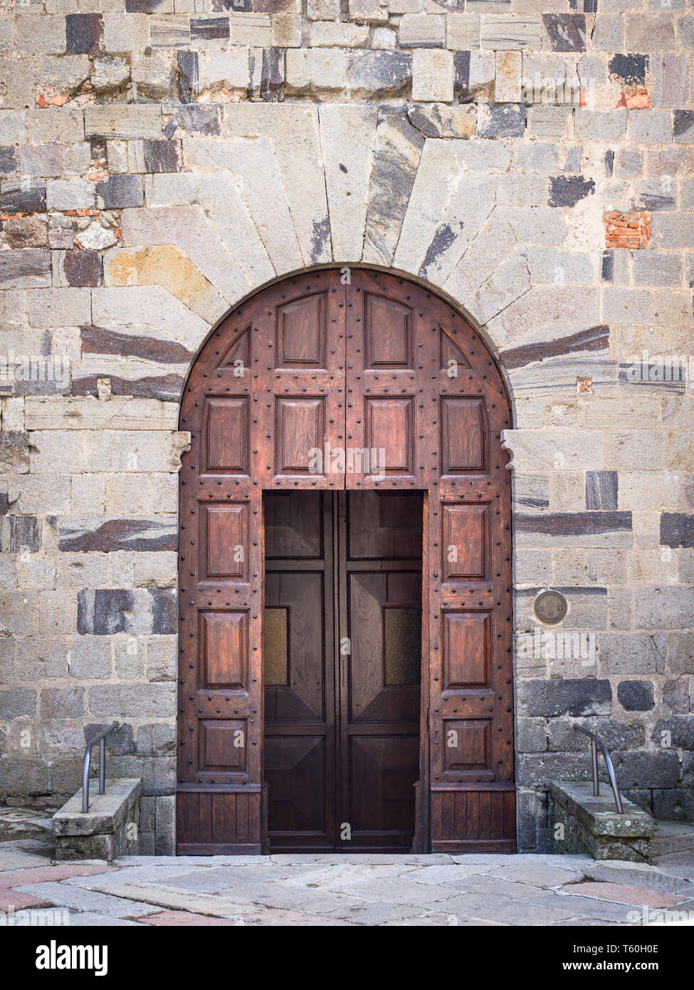 Ancient wooden portal with stone arch of an Italian medieval building ...