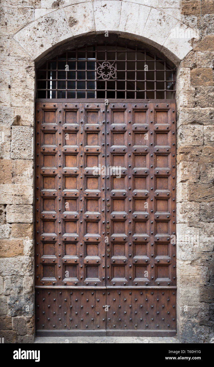 Ancient wooden portal with stone arch of an Italian medieval building ...