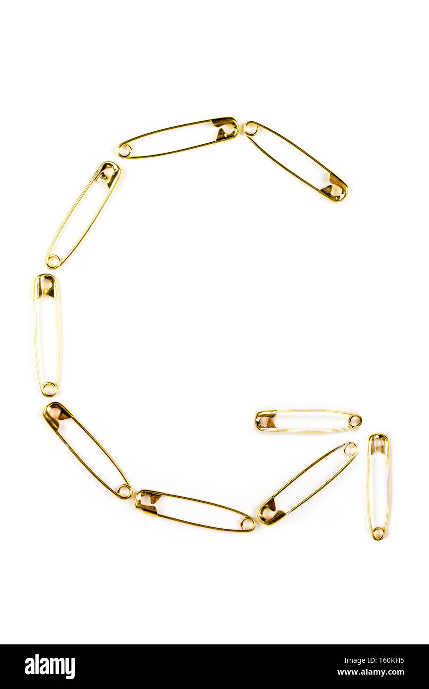 The letter "G" in gold colored safety pins Stock Photo - Alamy