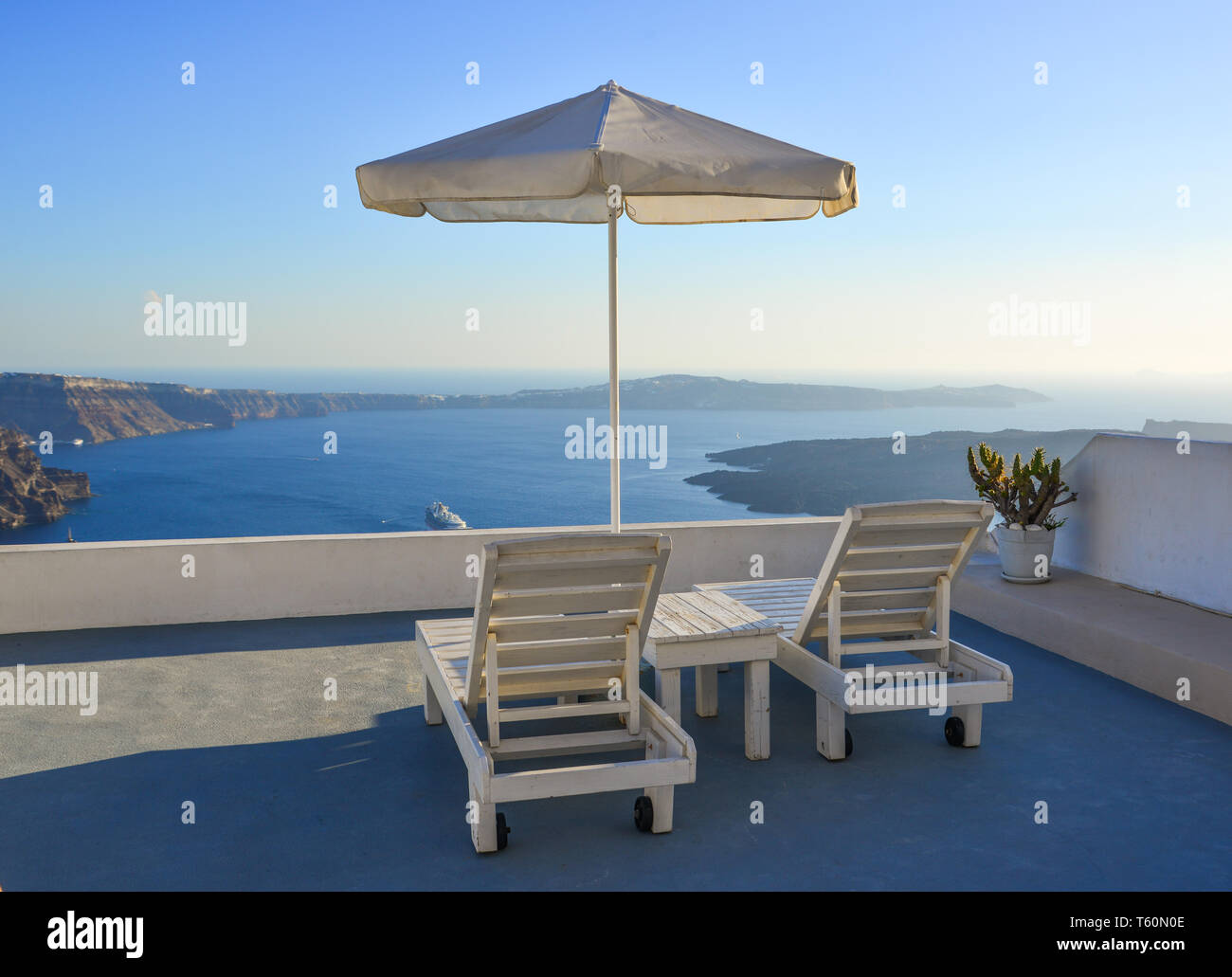 Seaview balcony with relaxing chairs and umbrella of white villa on ...