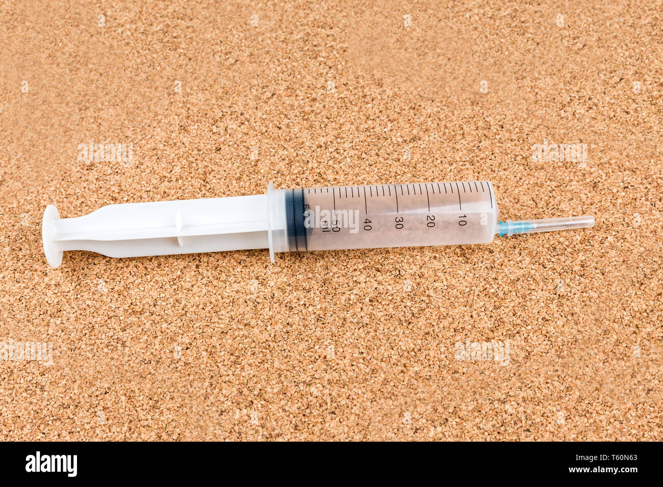 Empty large syringe and needle over cork board Stock Photo - Alamy
