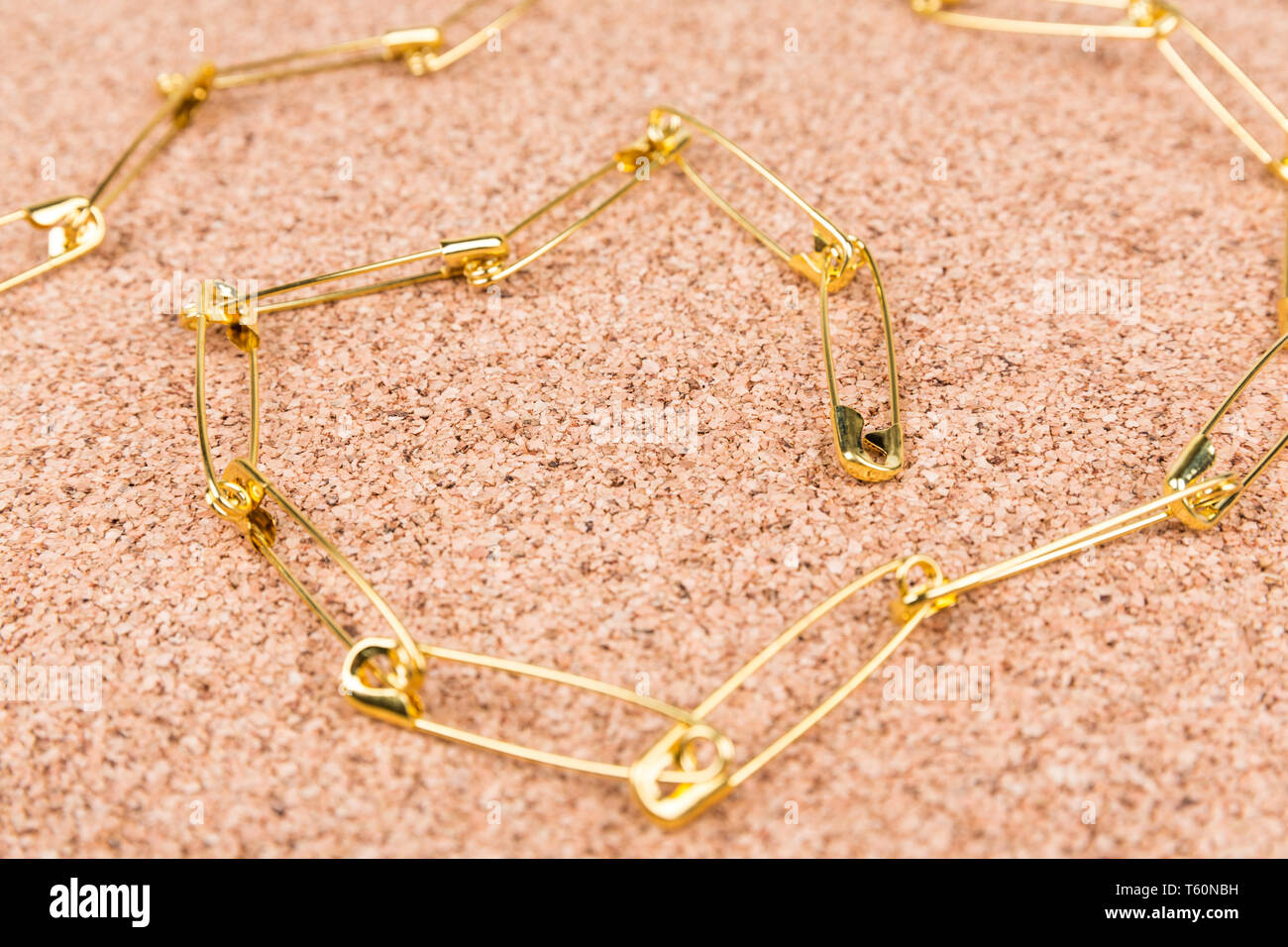 Several gold safety pin chain spread out Stock Photo - Alamy