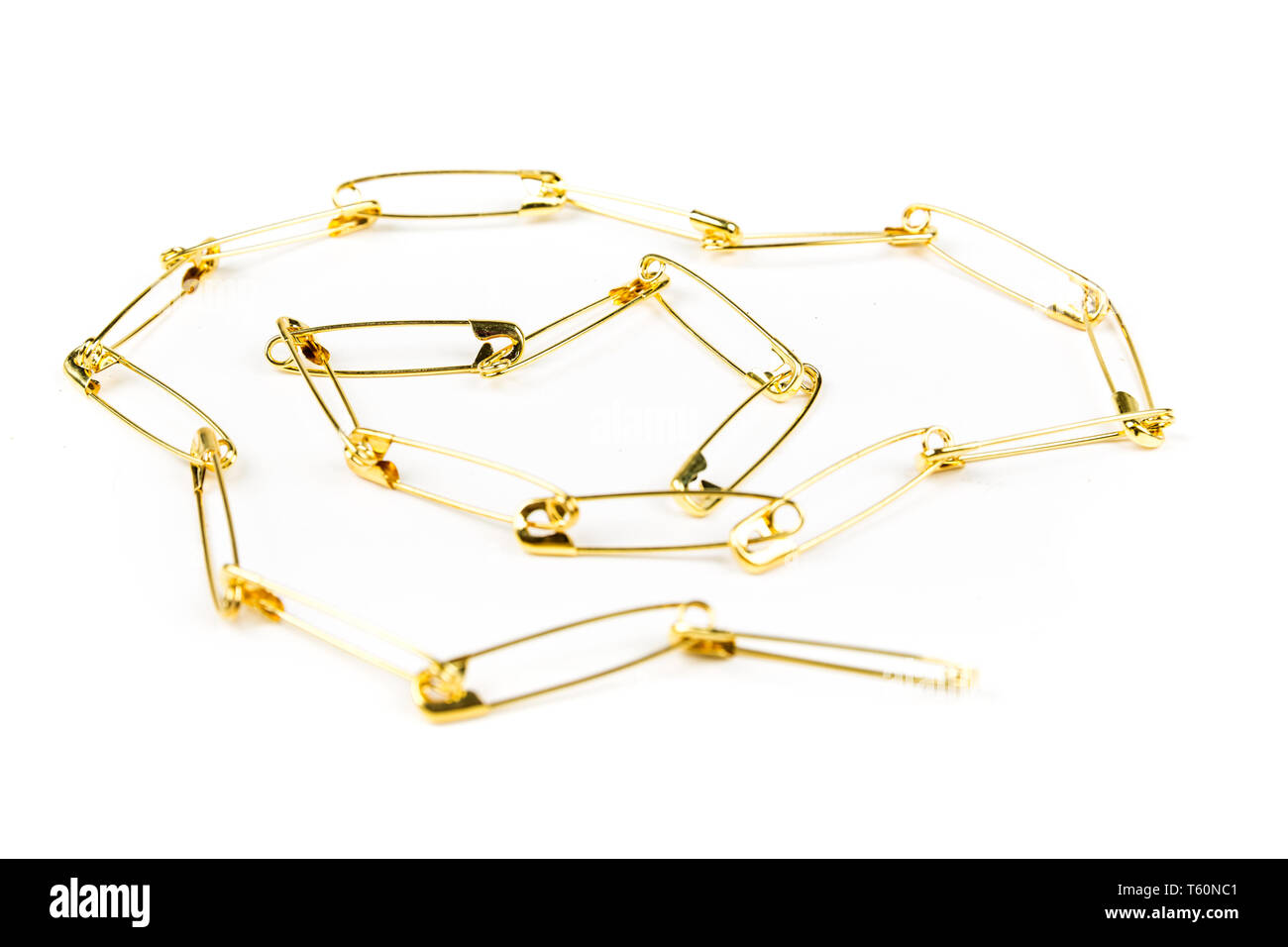 Several gold safety pin chain spread out Stock Photo - Alamy
