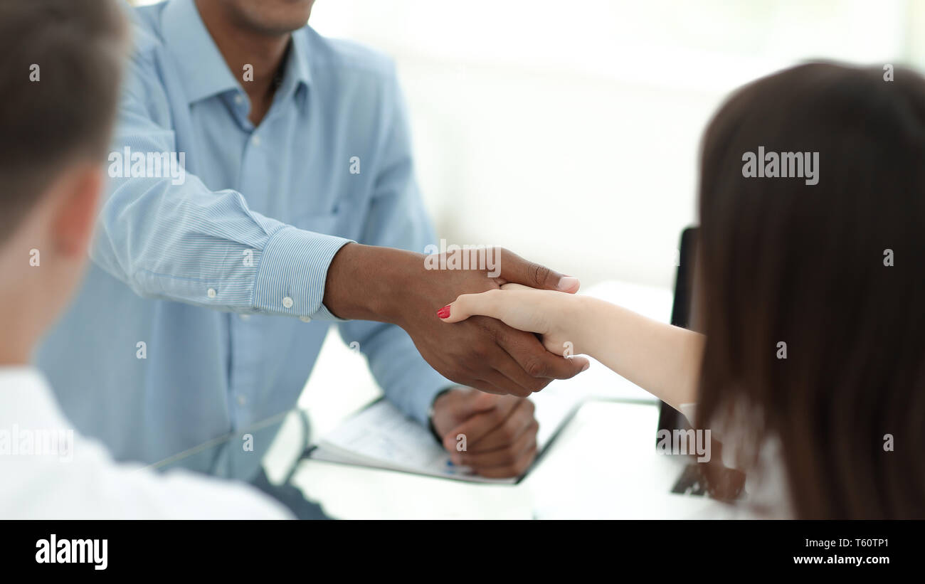 closeup.the handshake of employees in the workplace.the concept of ...