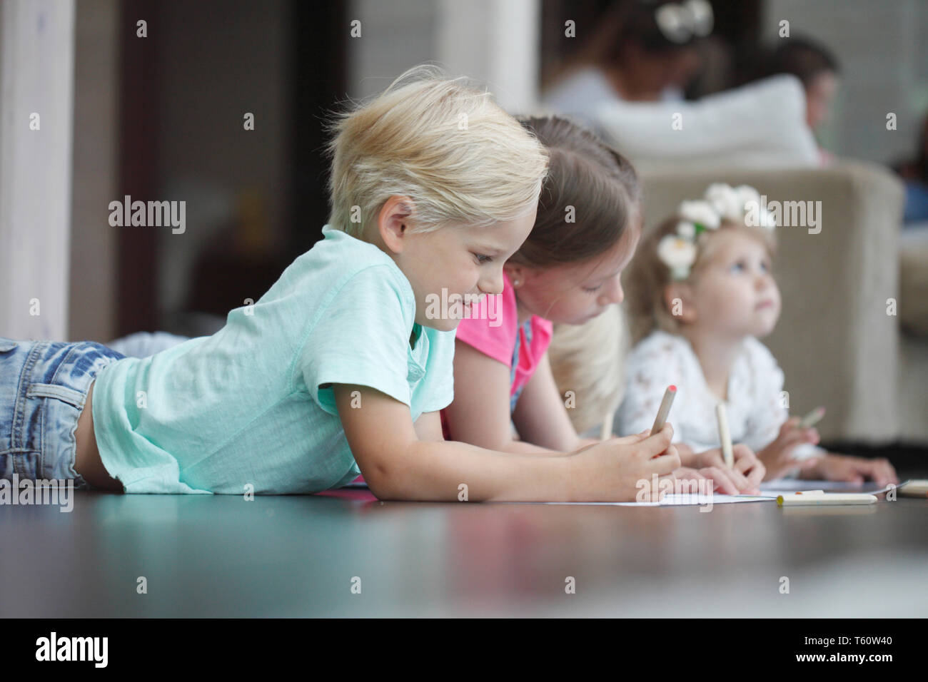 Group of cute children drawing with colorful pencils on floor Stock ...