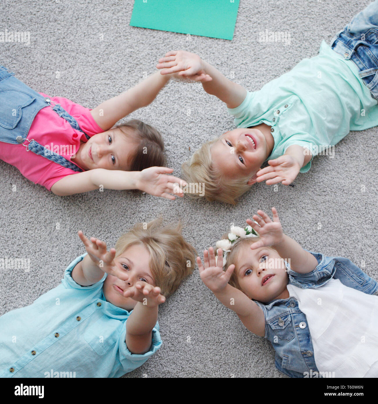 Group of happy kids laying on floor, top view Stock Photo - Alamy