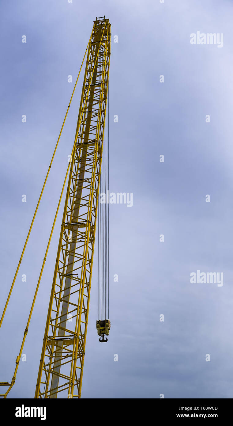 a large yellow crane with cloudy sky Stock Photo - Alamy
