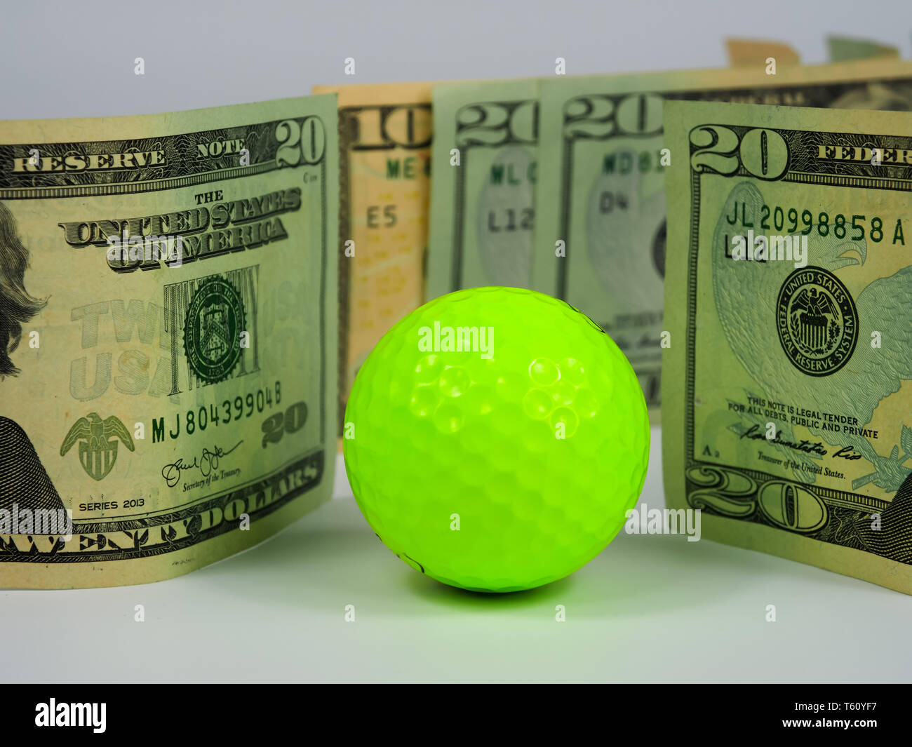making money, neon green golf ball and dollar bills with bright ...