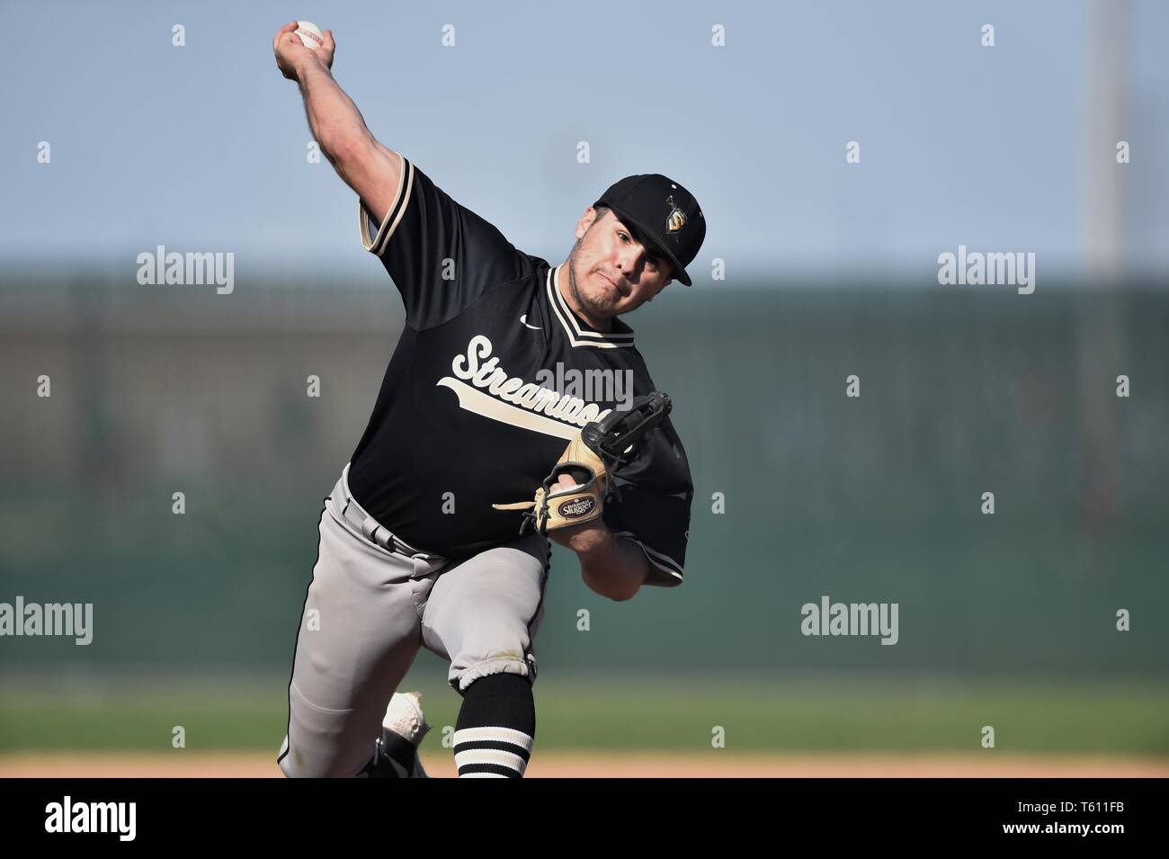 Pitcher delivering a pitch to a waiting opposing hitter. USA Stock ...
