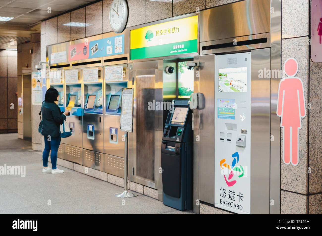 Asian woman buying a metro train ticket from an automatic ticket ...