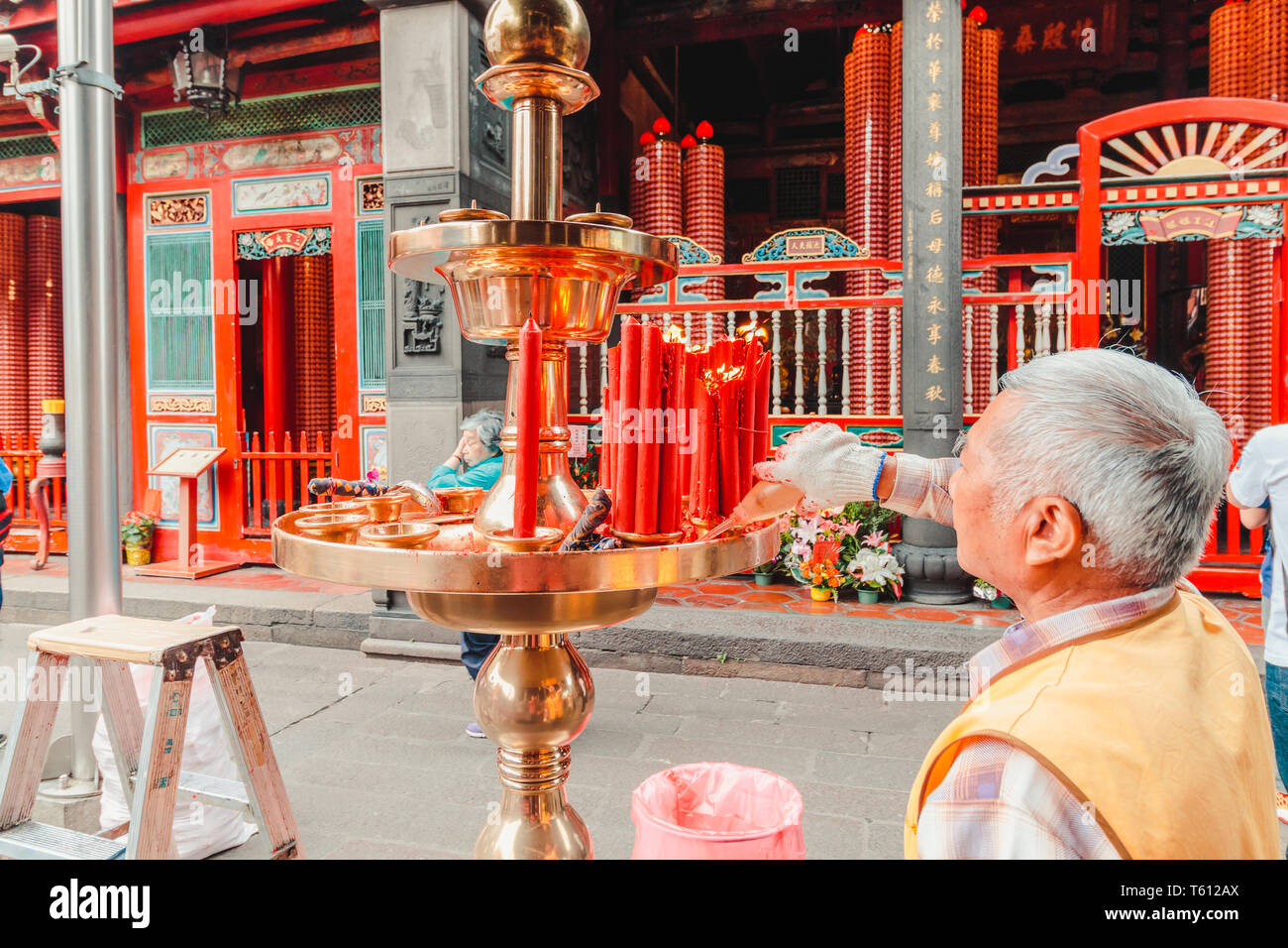 Staff at Longshan Temple lighting candle for visitor to burn the ...
