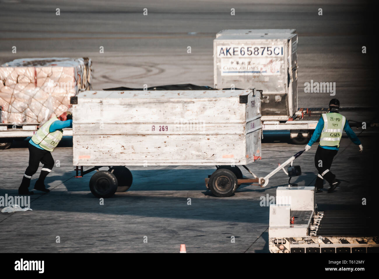Asian ground staff (ground crew) transporting cargo and luggage to the ...