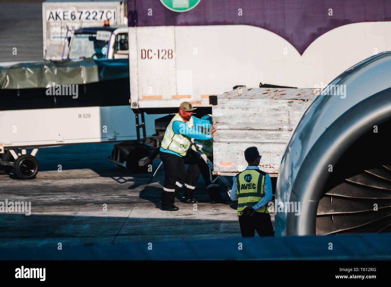 Asian ground staff (ground crew) transporting cargo and luggage to the ...
