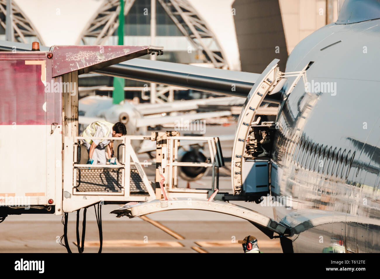Asian ground crew install a platform to load food and catering into the ...