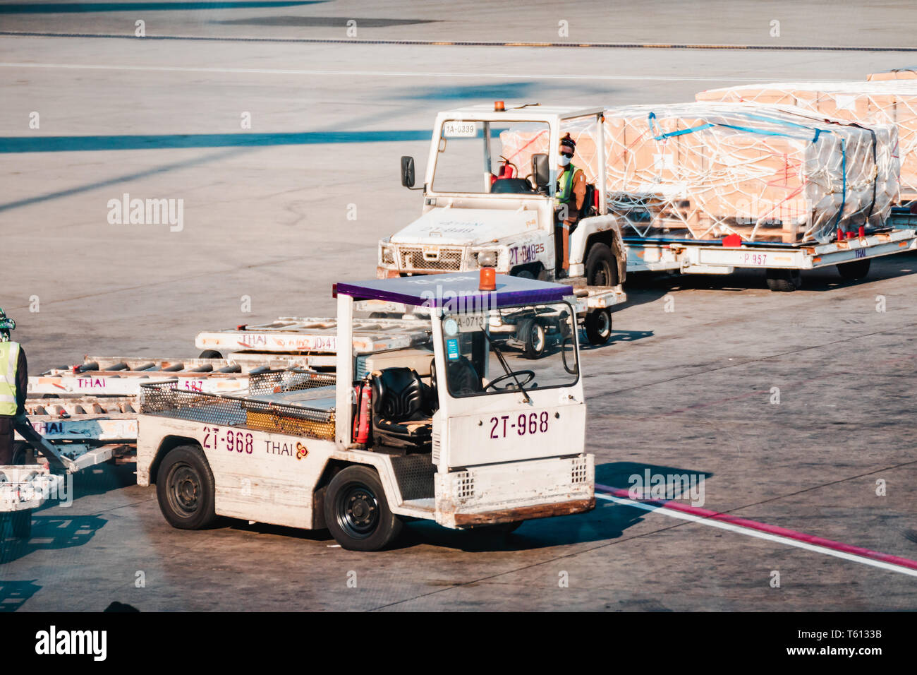 ground crew driving a cargo truck carrying cargo and mail to be loaded ...