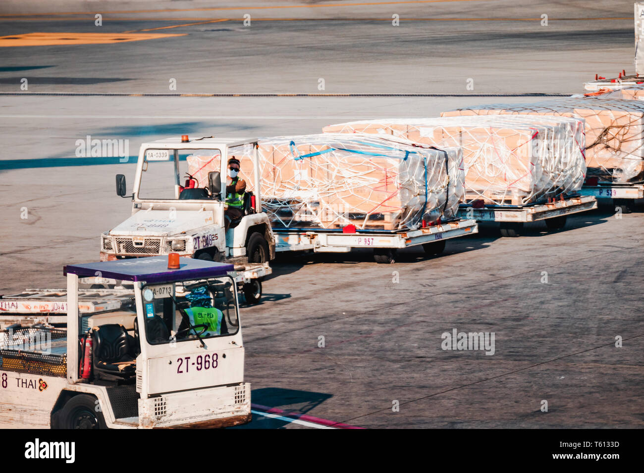 ground crew driving a cargo truck carrying cargo and mail to be loaded ...