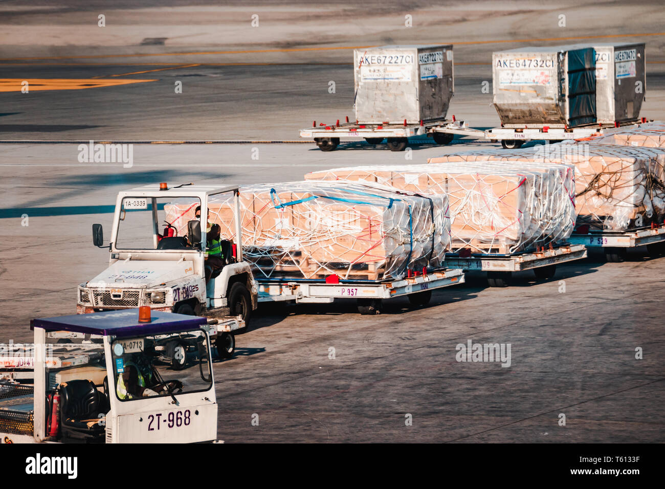 ground crew driving a cargo truck carrying cargo and mail to be loaded ...
